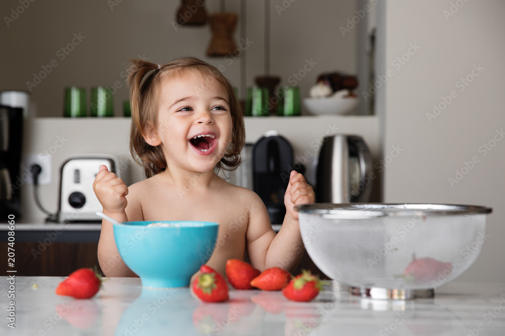 Shirtless toddler laughing at kitchen counter during afternoon ...