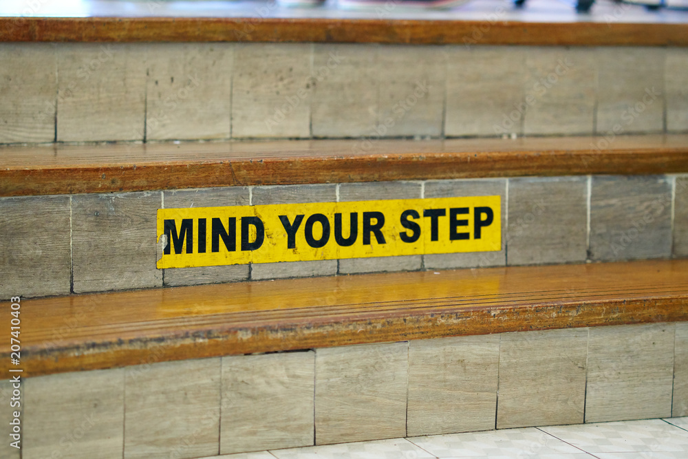 Stairs with"Mind your step" safety caution sign about slips, tri Stock ...