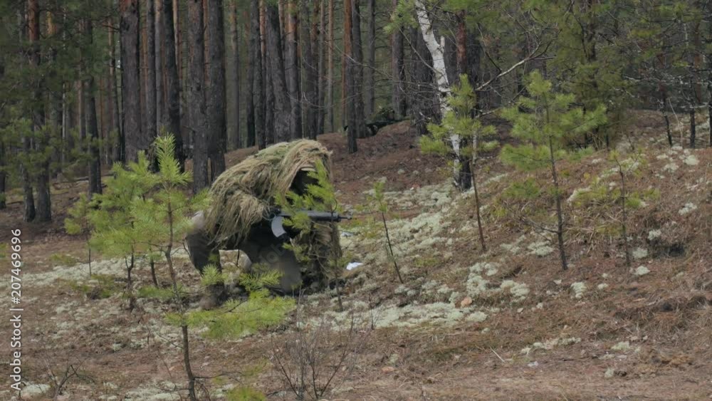 Soldiers in camouflage with combat weapons make their way outside the ...