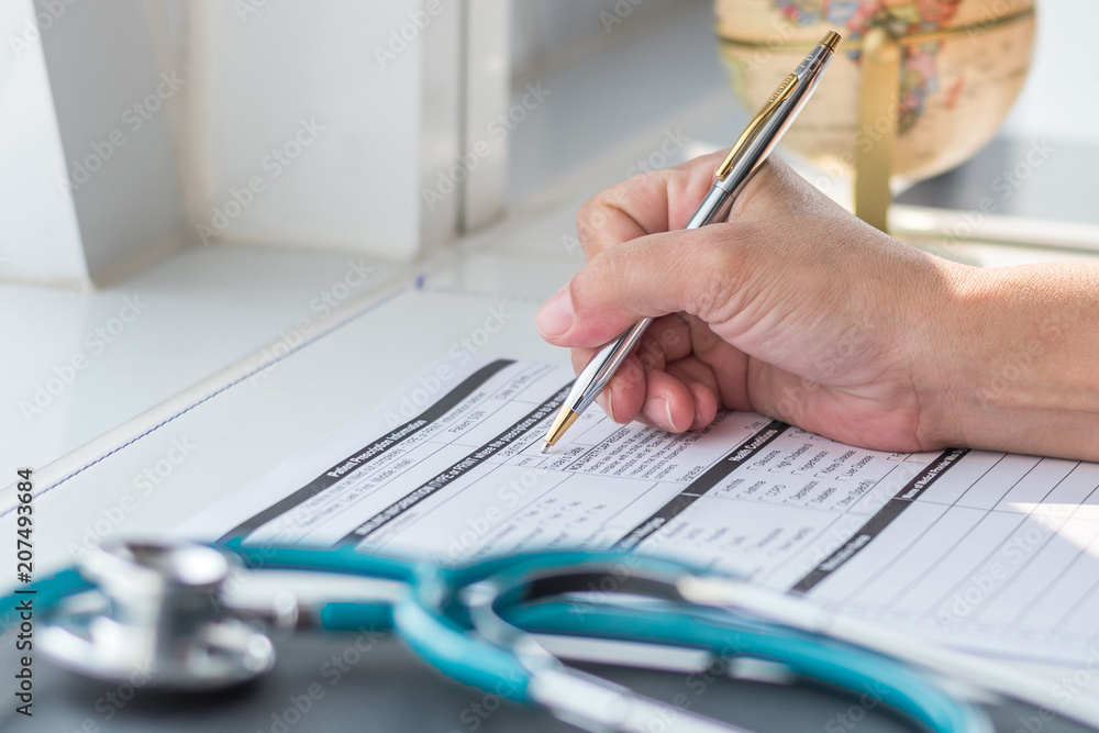 Doctor writing on medical health care record, patients discharge, or ...