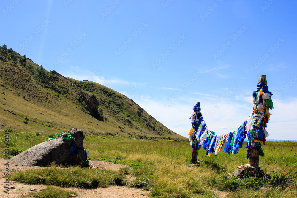 Colorful buddhist prayer flags hadags on ritual shamanic poles near the ...