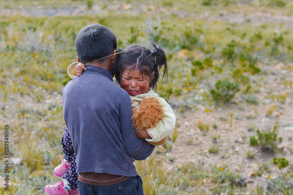 Native american boy holding his little sister who is crying. Stock ...