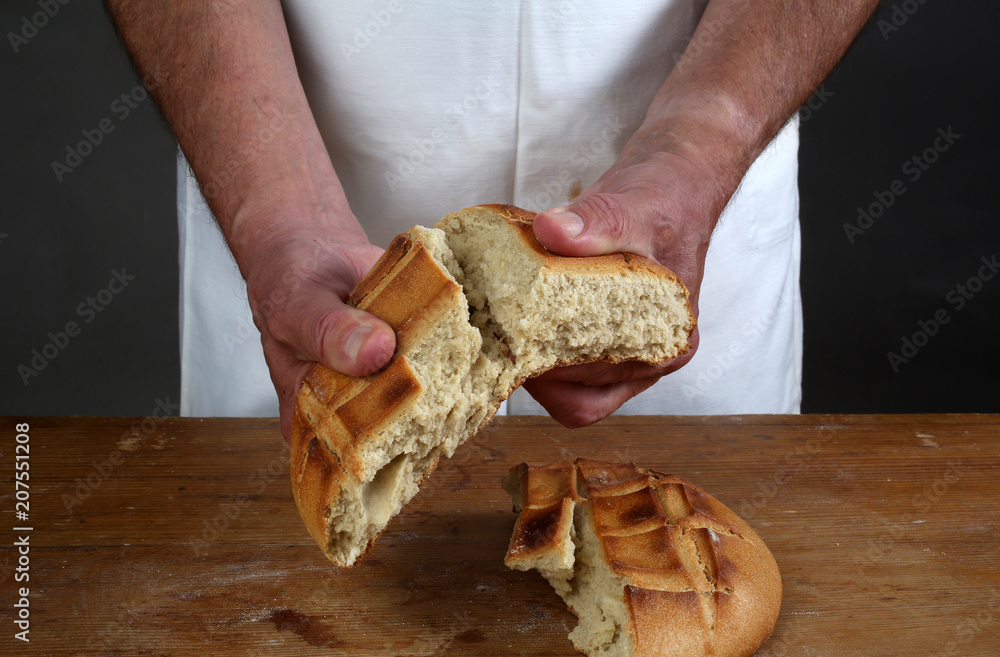Breaking of a fresh loaf of Eucharistic bread Stock Photo | Adobe Stock