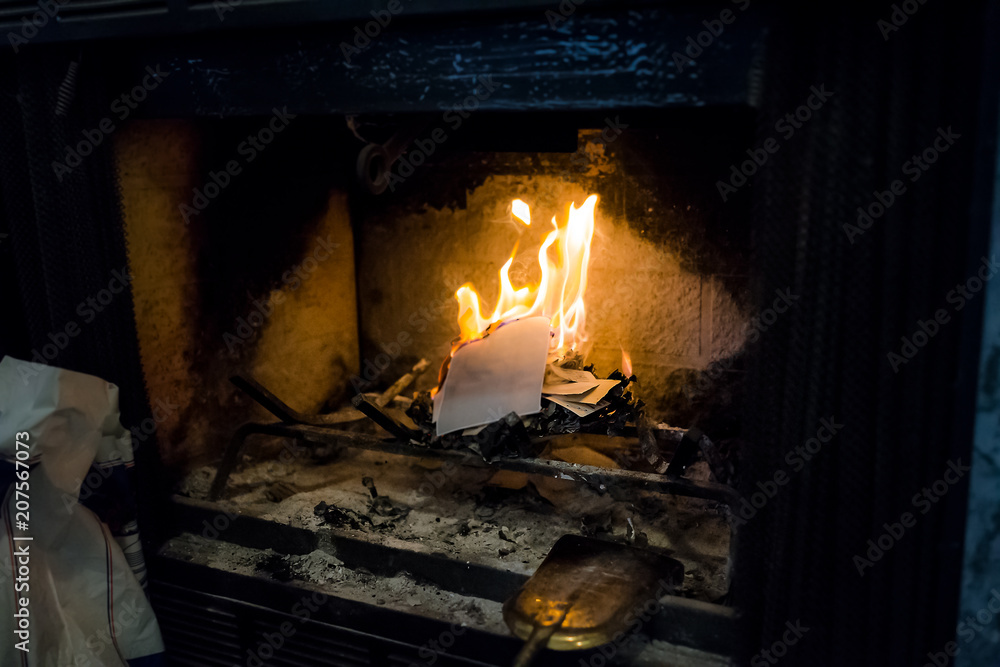 Burning paper, letters in indoor home interior fireplace with old retro ...