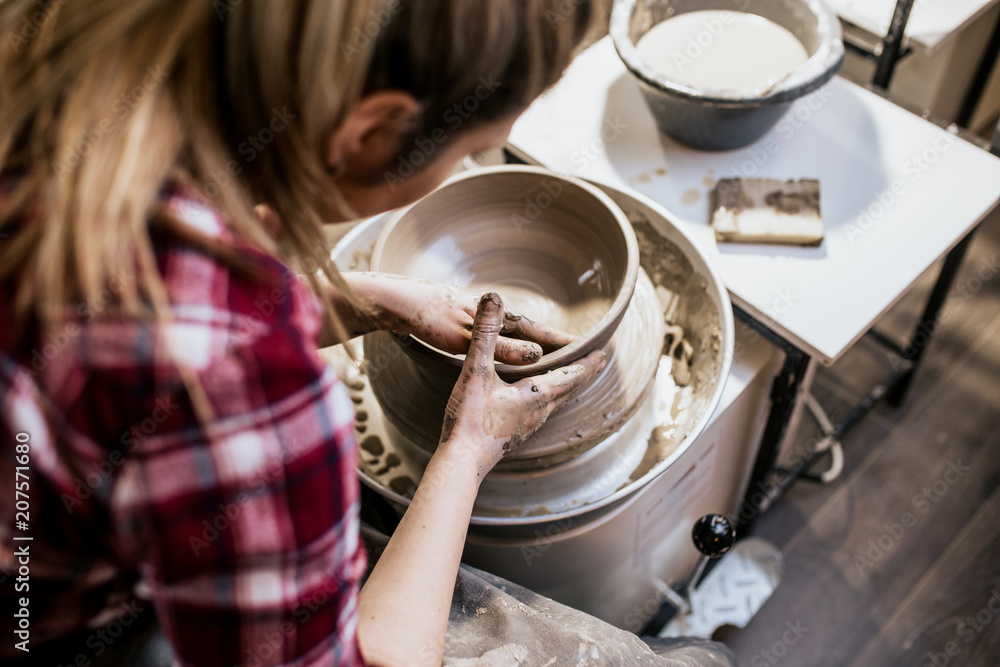 Female potter making clay pottery on a spin wheel. Stock Photo | Adobe ...