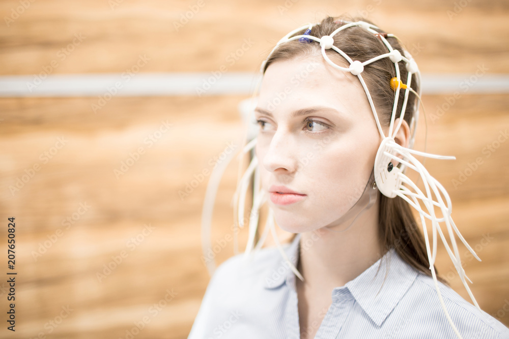 Young woman with eeg electrodes all around her head having medical test ...