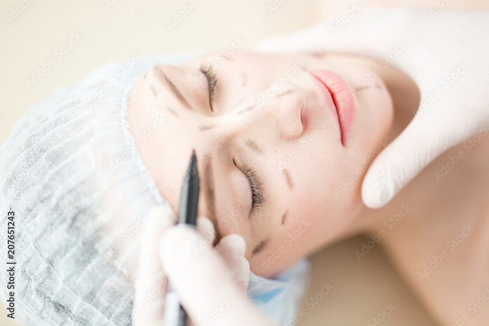 Doctor marking eye areas with black highlighter on face of young ...