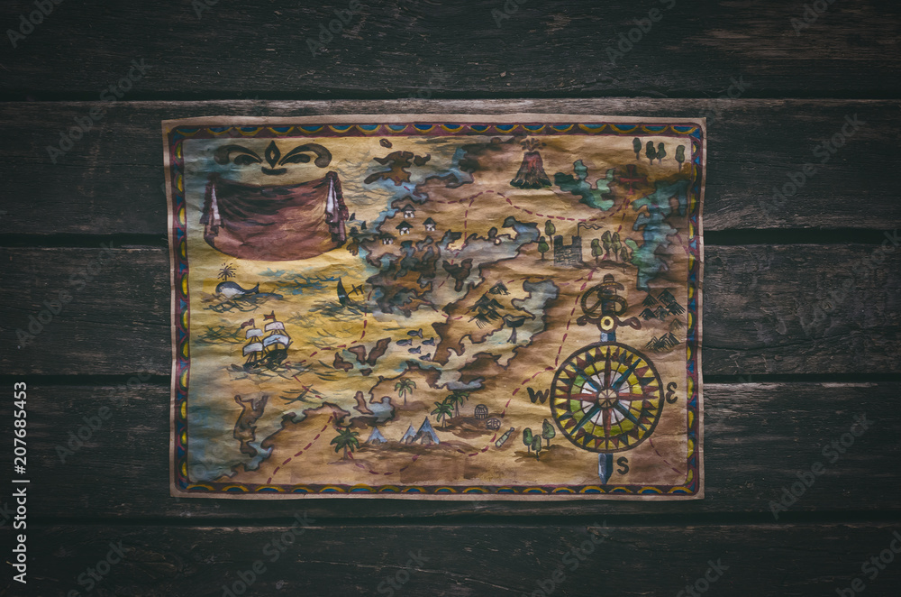 Pirate treasure map with gold mark on aged wooden table background. Top ...