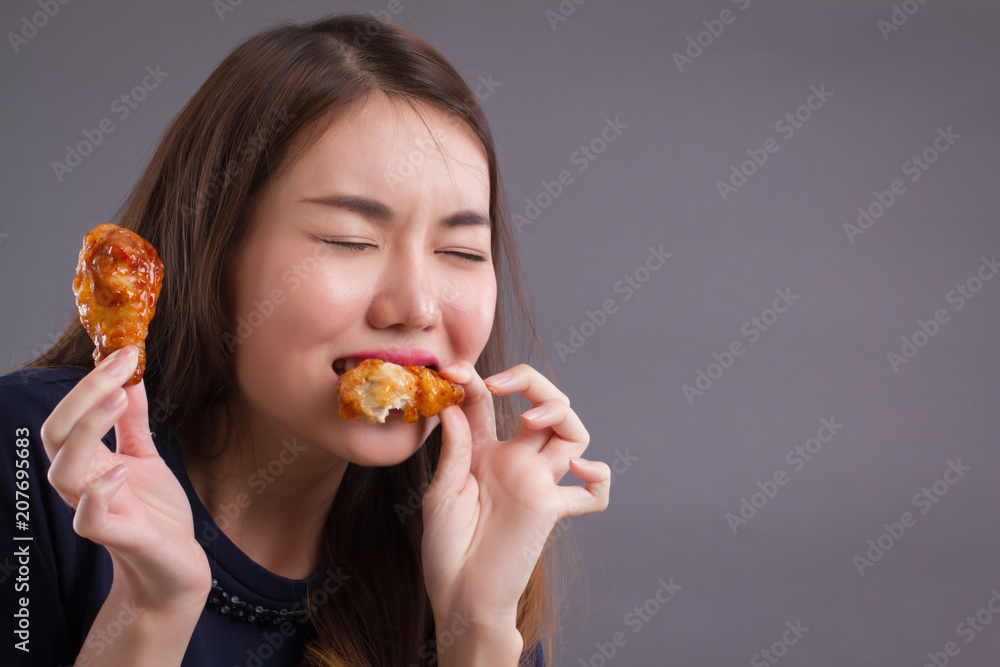 woman eating unhealthy fat fried chicken; portrait of unhealthy girl ...