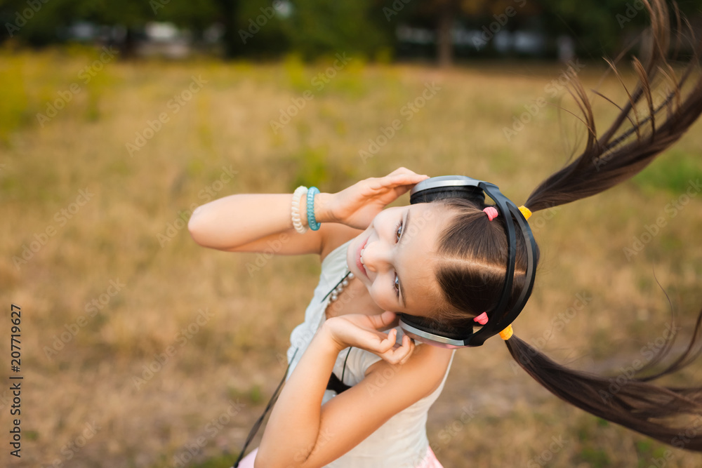 young girl twisting her head and waving her hair outdoor, nice child ...