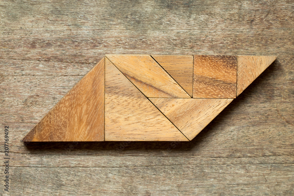 Tangram puzzle in parallelogram shape on wood background Stock Photo ...