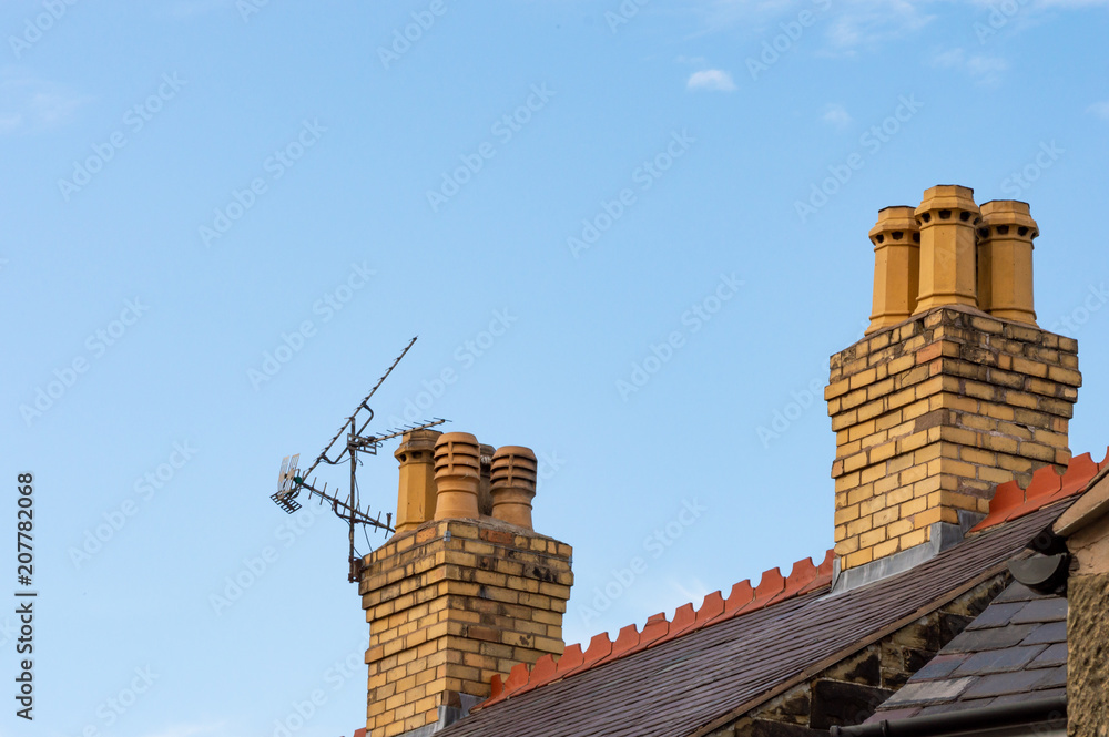 Old residential rooftop and chimneys with TV ariel. Slate roof ...
