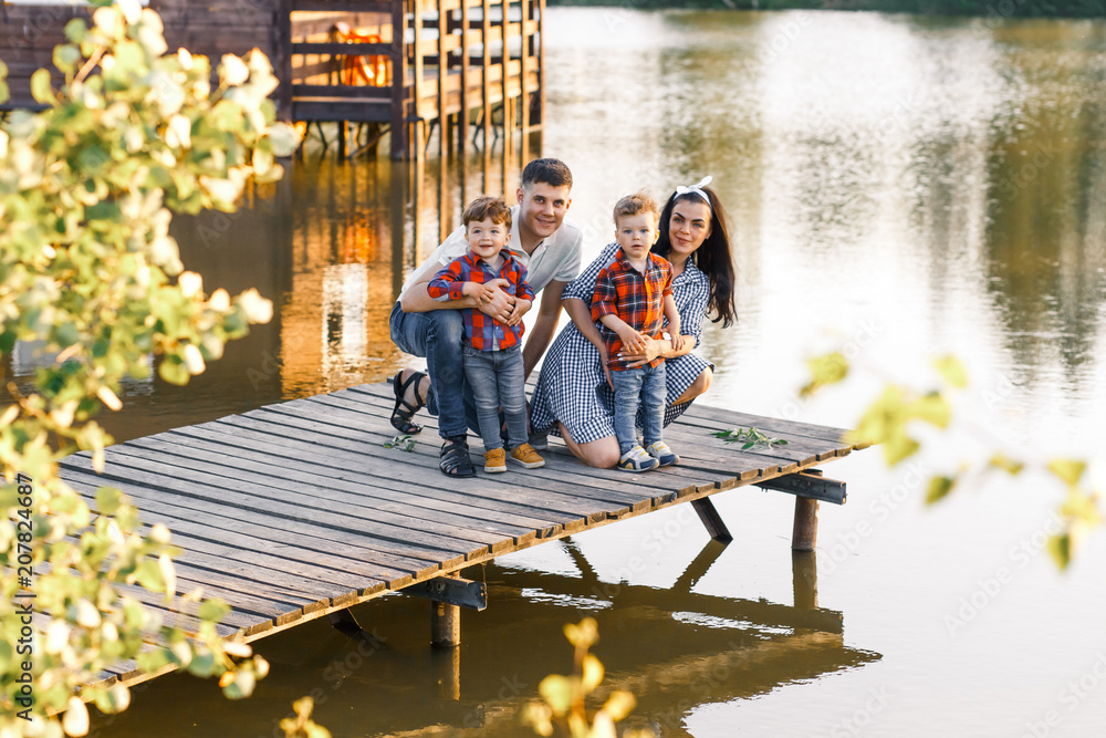 Foto de Happy young family spending time together outside in green ...