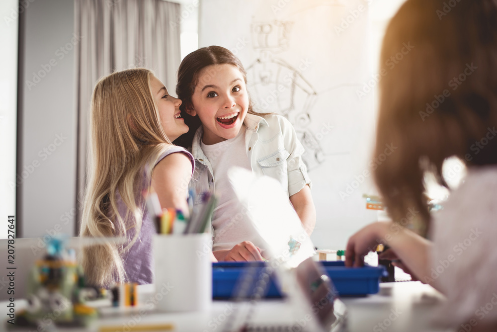 Outgoing girl talking with cheerful friend. They making toy. Positive ...