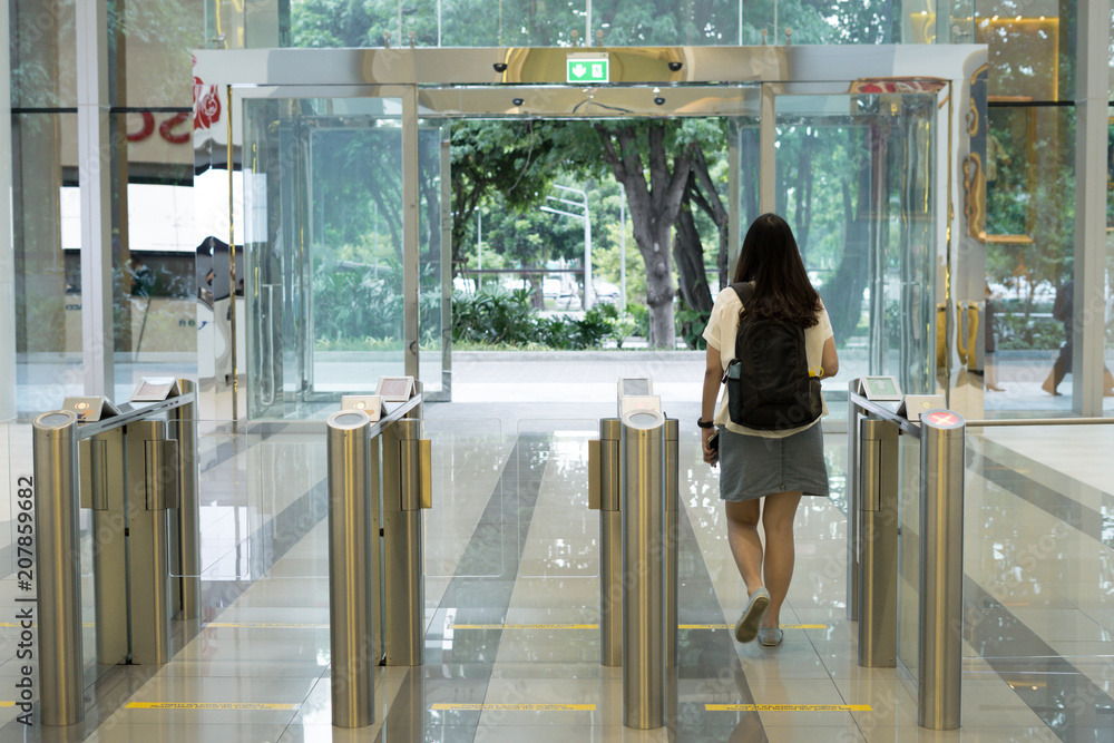 women people walking out from security at an entrance gate with key ...