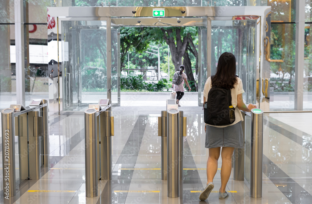 women people walking out from security at an entrance gate with key ...