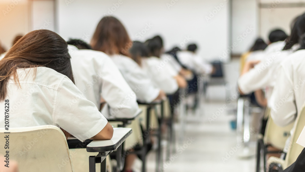 School student exam in university class with blurry view from back of ...