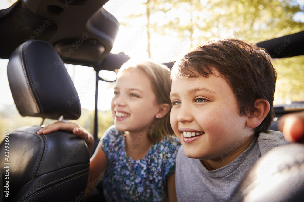 Children Sitting In Back Seat Of Open Top Car On Road Trip Stock Photo ...