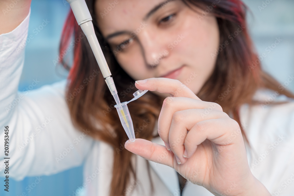 Woman technician with multipipette in genetic laboratory PCR research ...