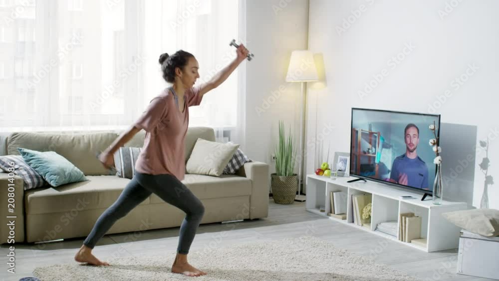 Wide shot of young woman doing scissor jumps and high knee skips with ...