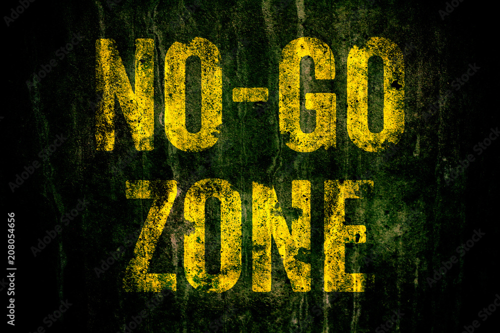 “No-Go Zone” warning sign in yellow letters painted over dark grungy ...