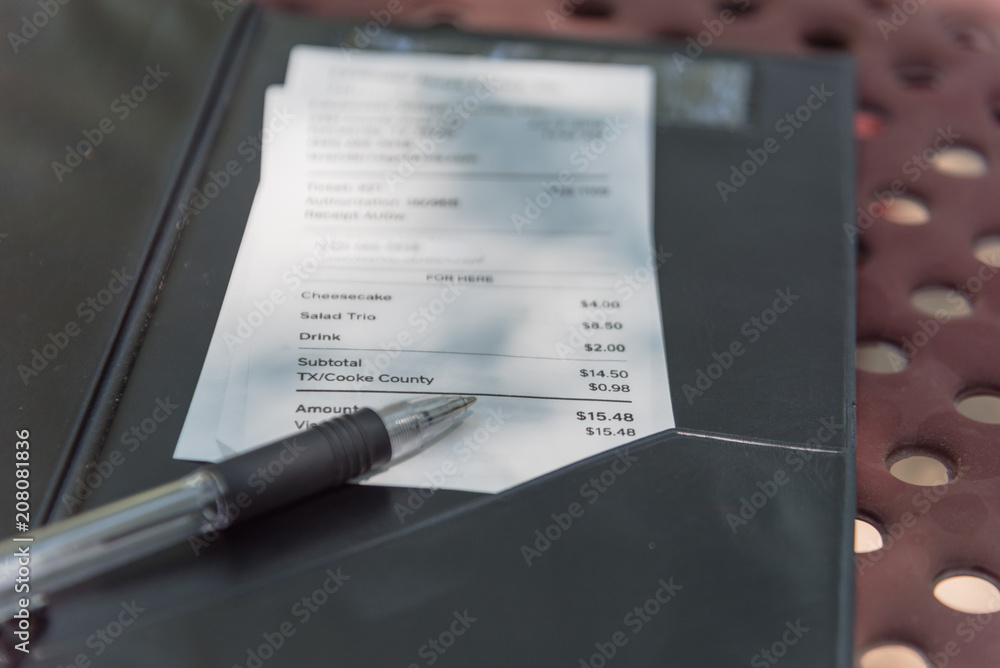 Close-up open leather bill holder with restaurant check and pen. Top ...