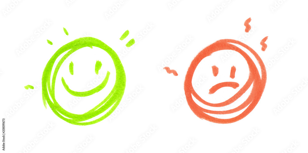 One round green happy face and one round red sad face painted in ...