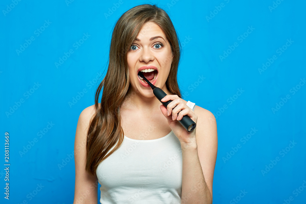 Woman using electric toothbrush. Isolated portrait Stock Photo | Adobe ...