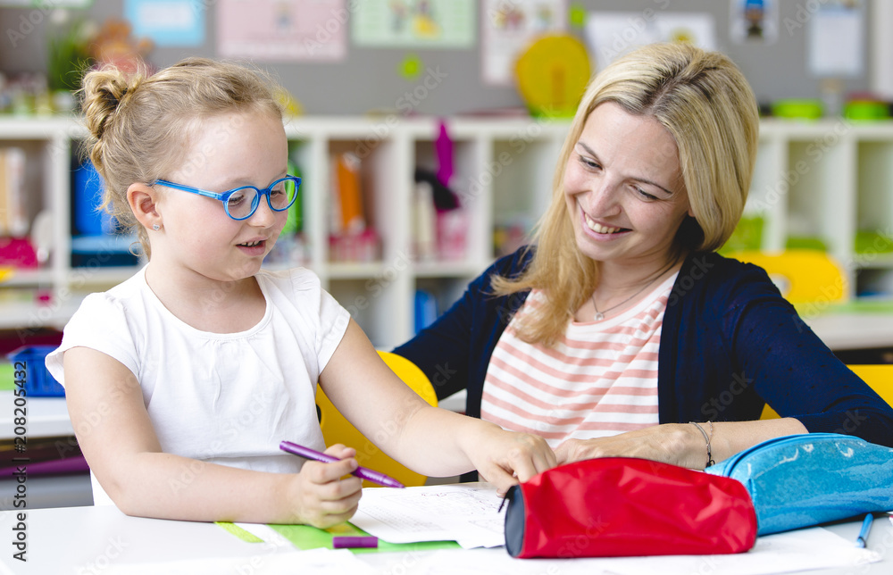 Lehrerin hilft Schülerin beim Lernen Stock-Foto | Adobe Stock