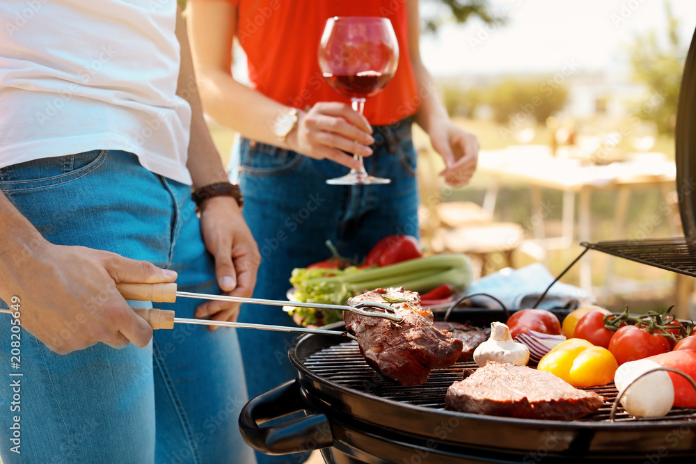Young couple having barbecue with modern grill outdoors Stock Photo ...