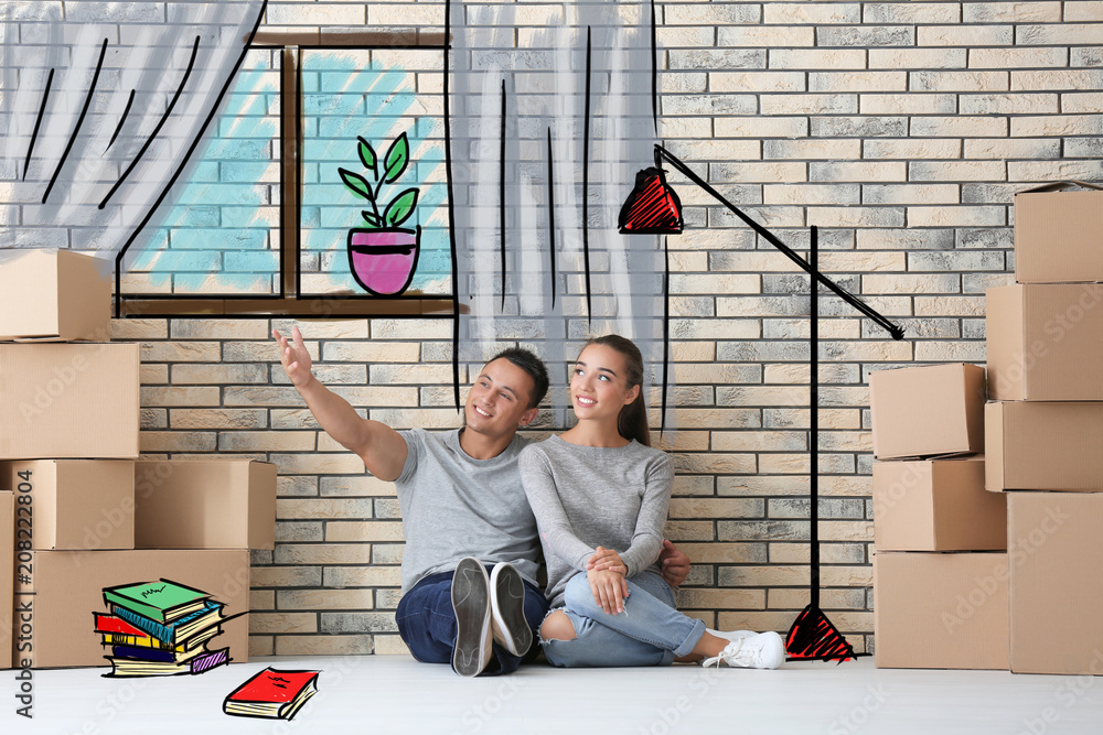 Young couple dreaming about moving into new house on brick wall ...