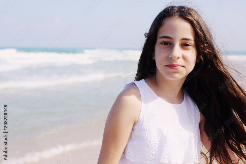 Portrait of aborable 12 years old girl walking alone on the beach in ...