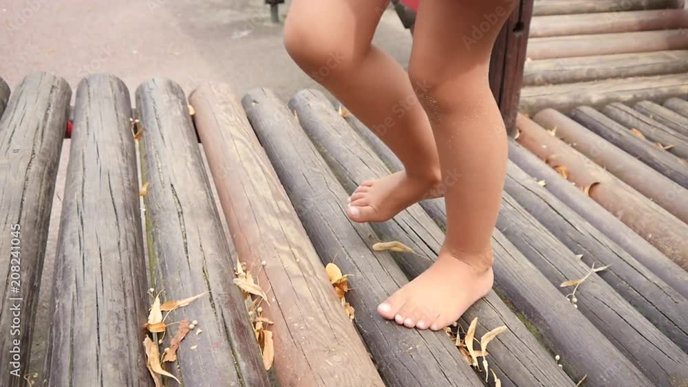 Barefoot legs kid girl play on park playground for children enjoy to be ...