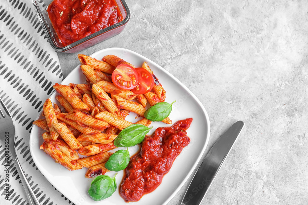 Plate with delicious penne pasta and garnish on table Stock Photo ...
