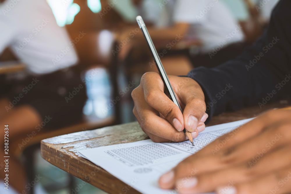 Students writing pen in hand doing exams answer sheets exercises in ...