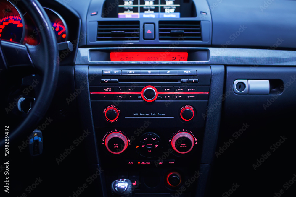 Car radio and air conditioner system. Button on dashboard in modern car ...