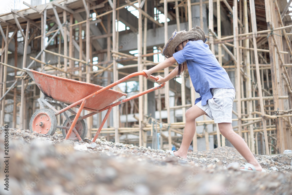 Foto de Little girl labor working in commercial building structure ...