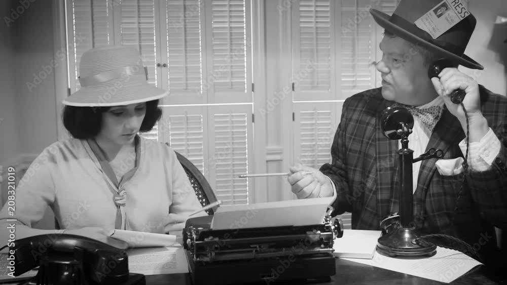 Reporters from 1940s era in news room one on the phone other grabs an ...