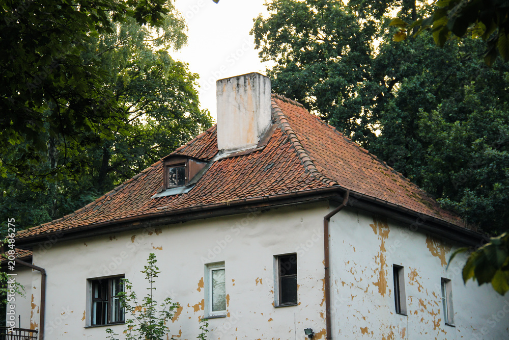 Old classic two-storey stone house with red clay tile roof with brick ...