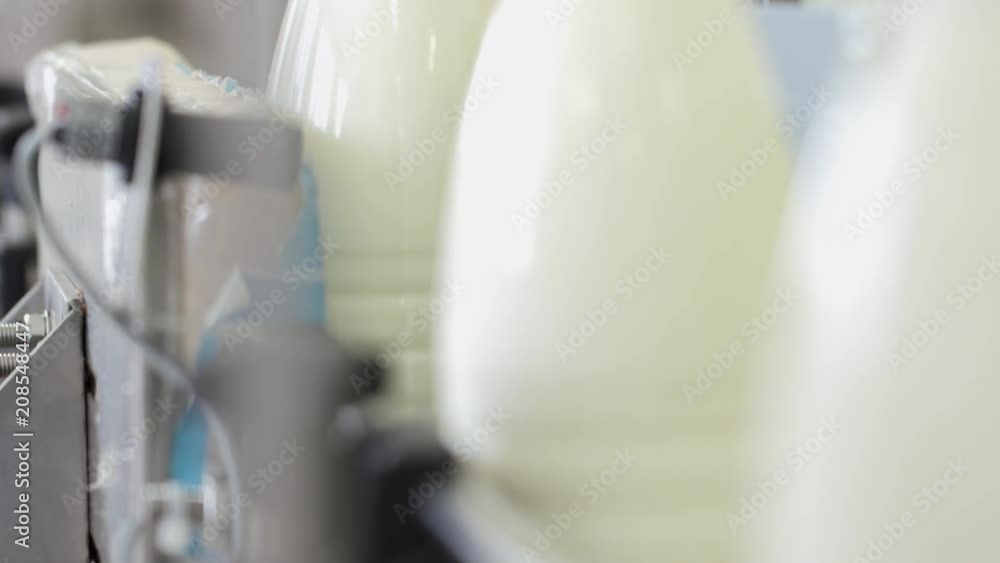 Factory milk making process. Close up packing milk plastic bottles ...