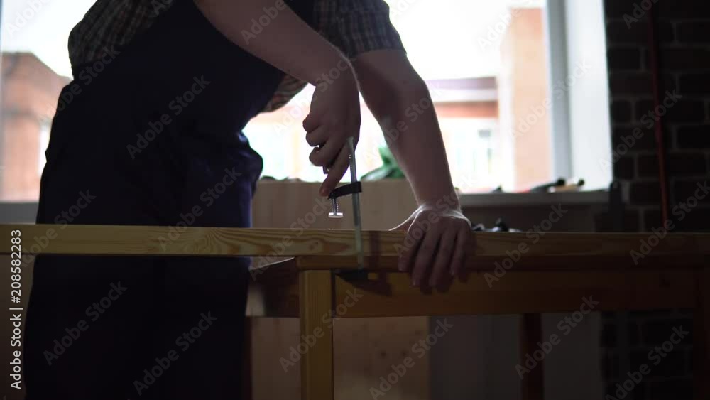 The process of building a wooden table, the carpenter measures the ...
