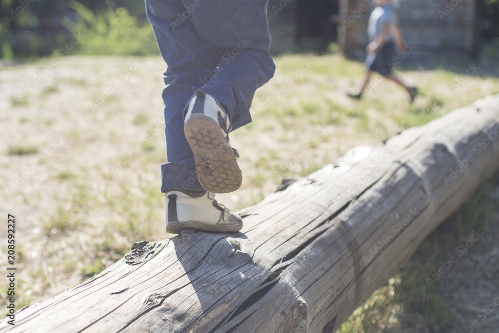 Little boy walking on a log in the park. child on the balance beam ...
