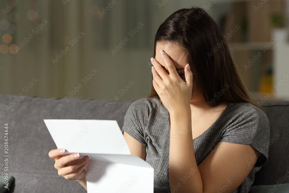 Sad woman reading a letter in the dark Stock Photo | Adobe Stock