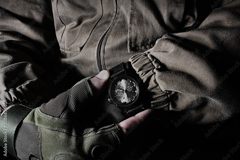Profile view photo of a male person in brown tactical outfit jacket and ...