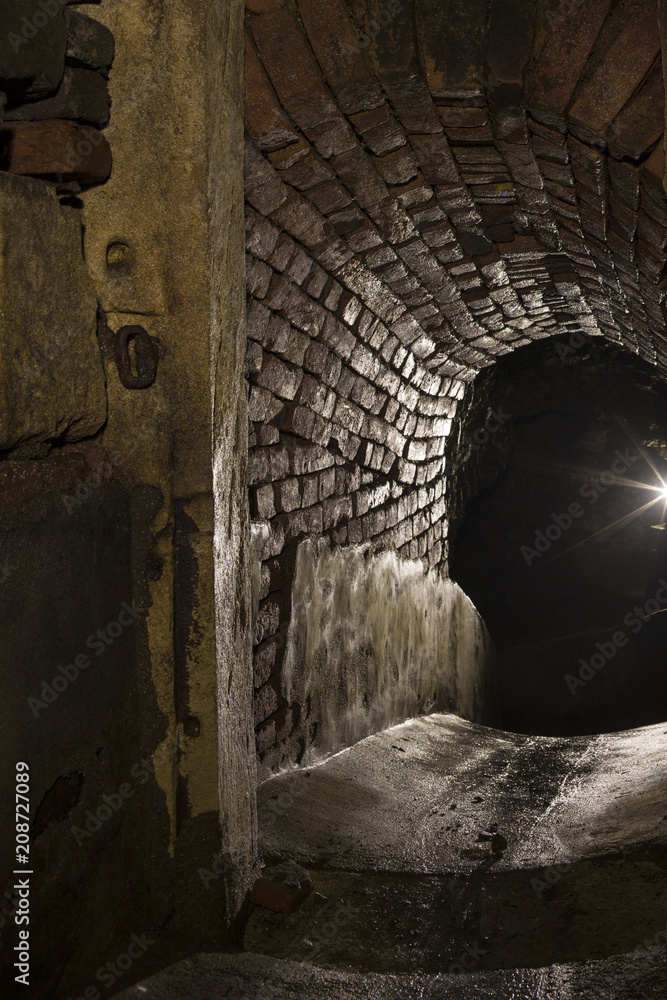 Old historic medieval mine with arched brick ceiling illuminated by ...
