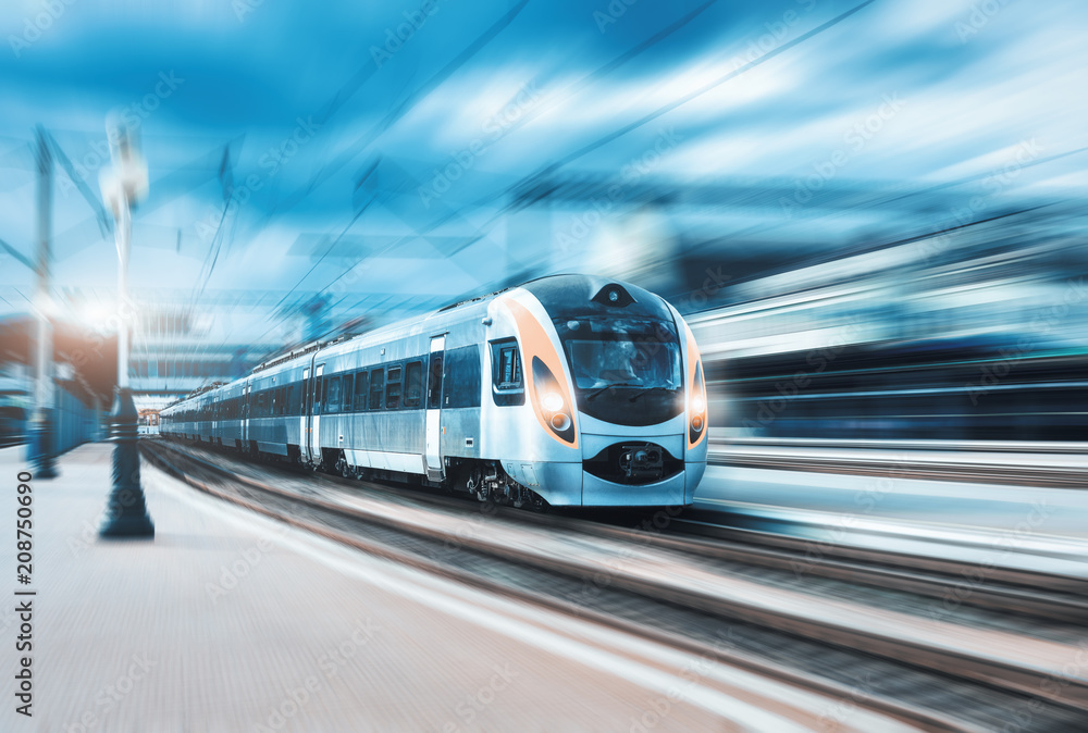 High speed passenger train in motion on the railway station at sunset ...