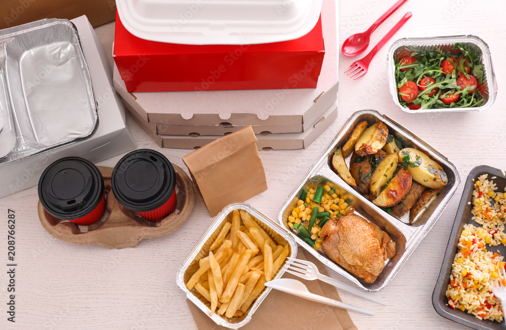 Containers with tasty takeout meals on light background, top view. Food ...