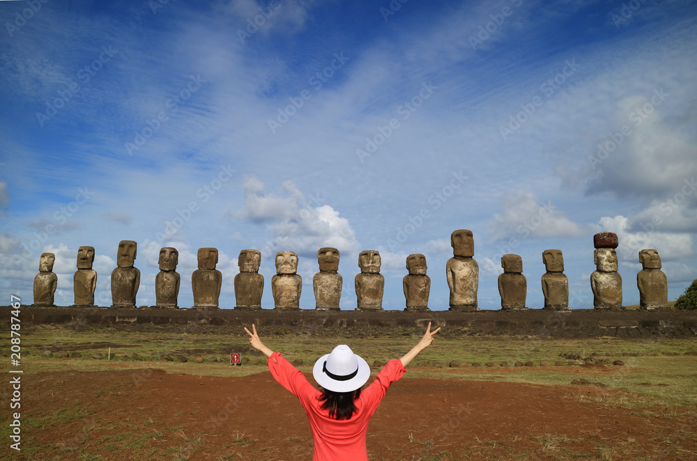 One female raising her arms happily in front of Moai statues of Ahu ...