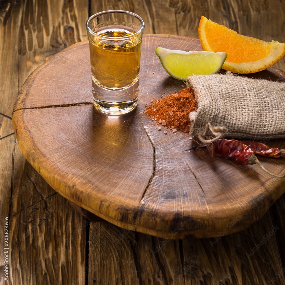 Mezcal shot mexican drink with orange and lime slices, chili pepper and ...