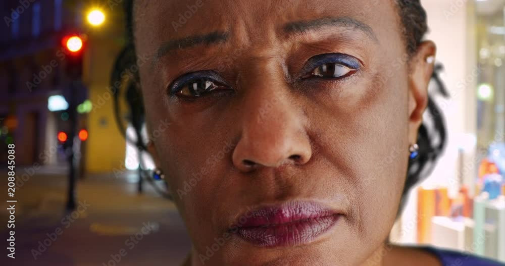 Vidéo Stock Elderly black woman standing on urban street at night ...